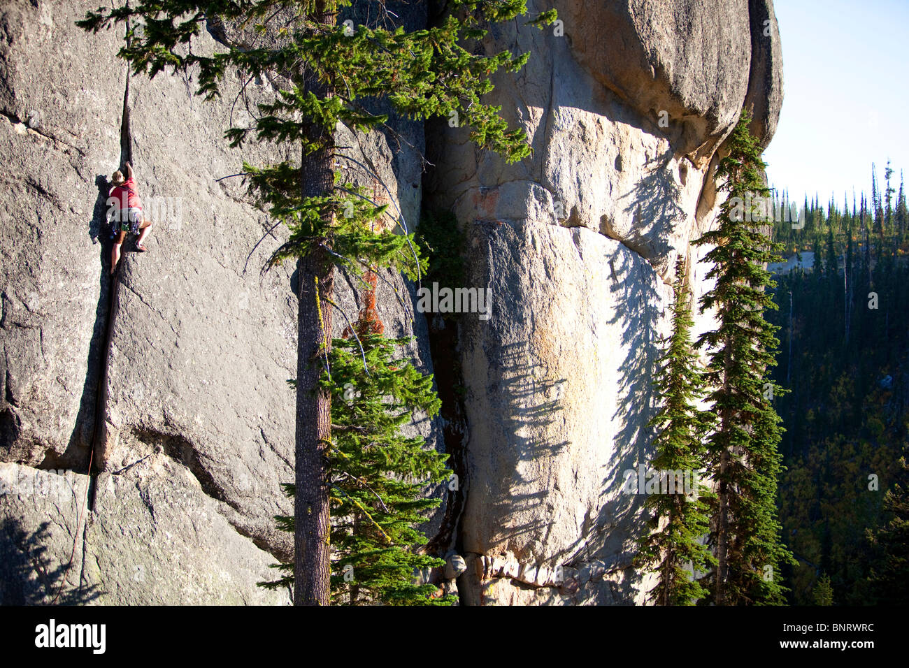 A male rock climber ascends a route in the traditional style, Lolo ...