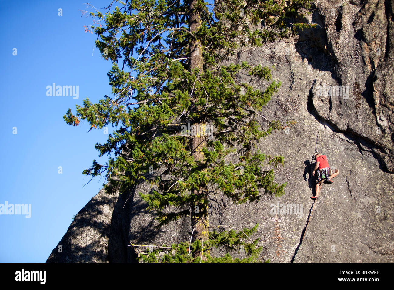 A male rock climber ascends a route in the traditional style, Lolo ...