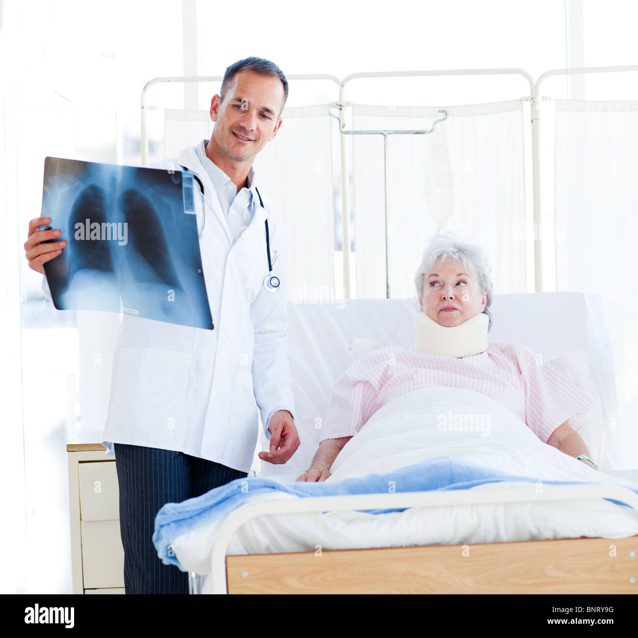 A doctor showing an x-ray to a patient Stock Photo - Alamy