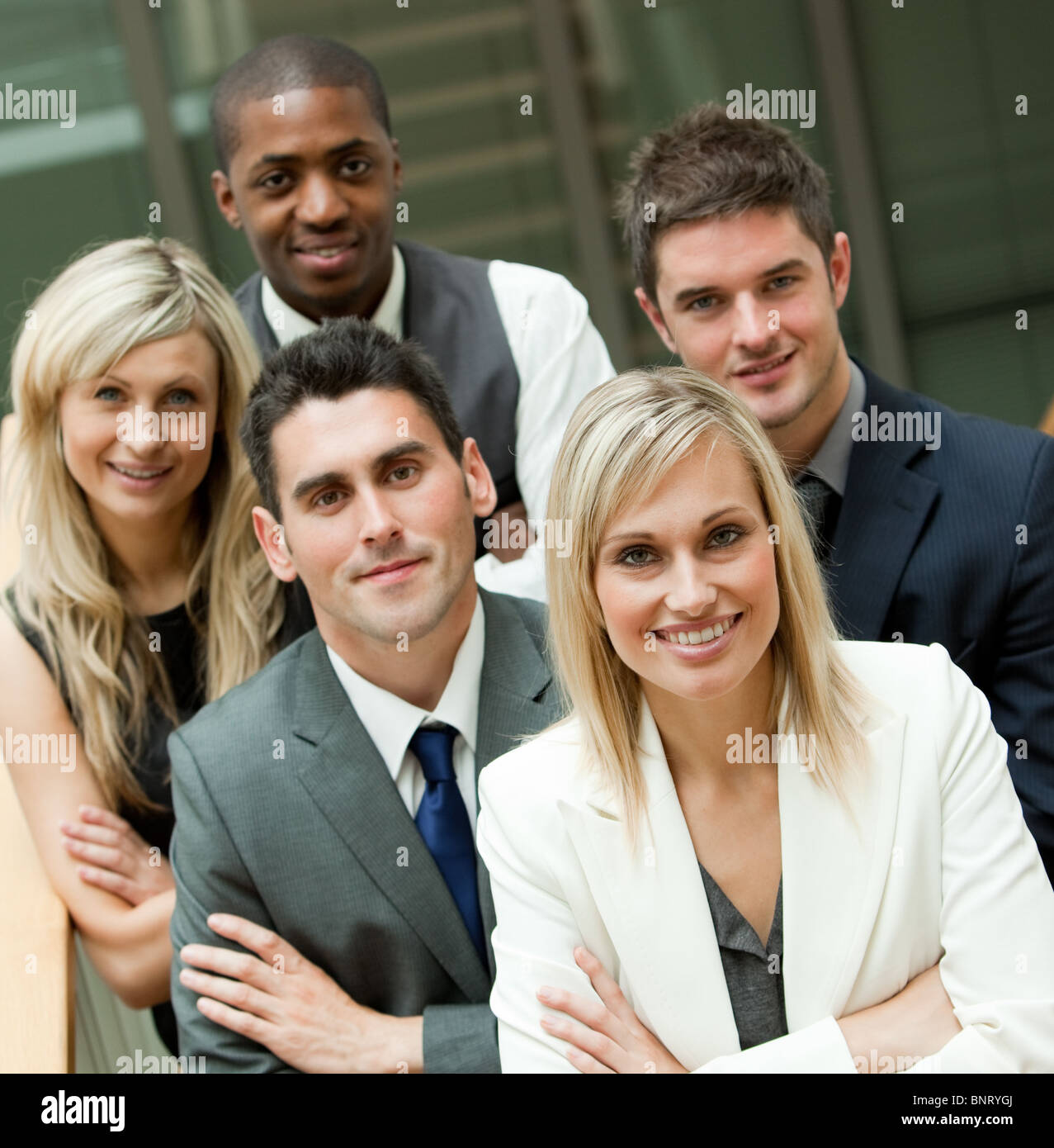 Smiling business team looking at the camera Stock Photo - Alamy