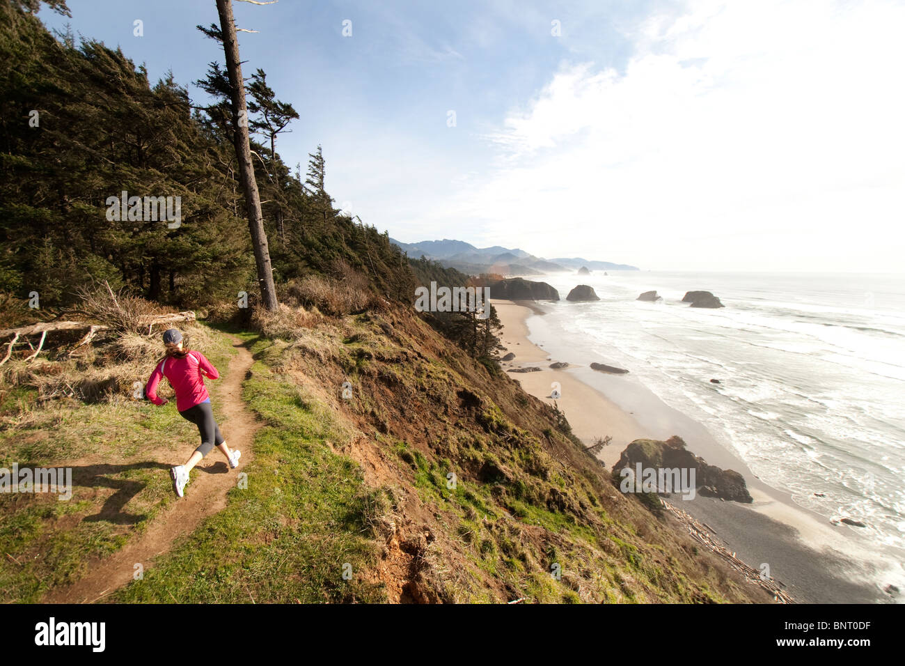 Woman trail running along the Oregon coast Stock Photo - Alamy