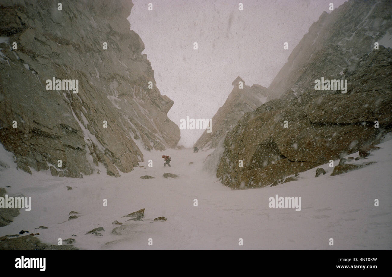Two mountain climbers descend steep snow gully during snow storm Stock ...