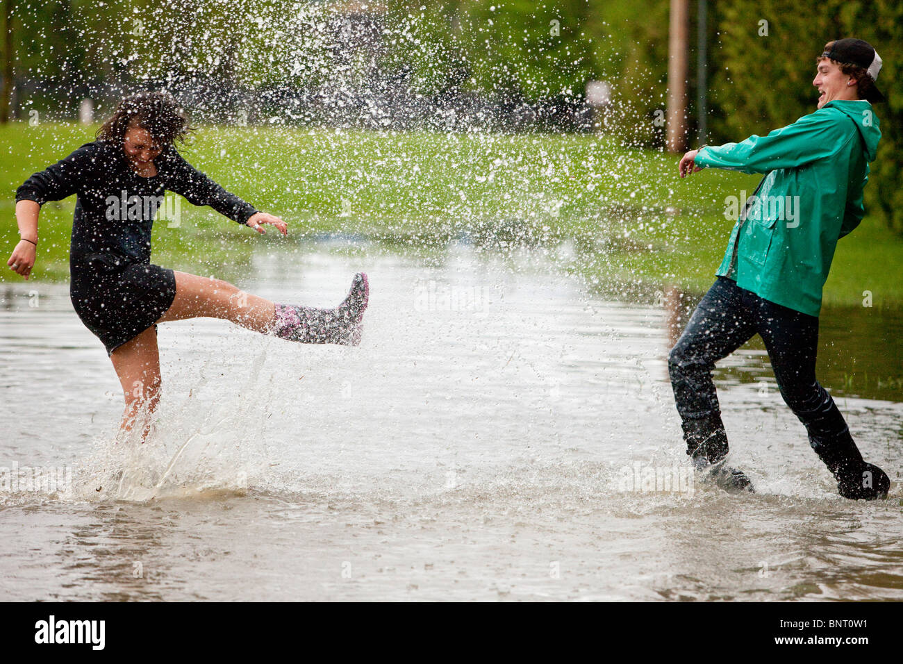 Splash In The Puddle A Joyful Child Wearing Colorful Rain Boots Is