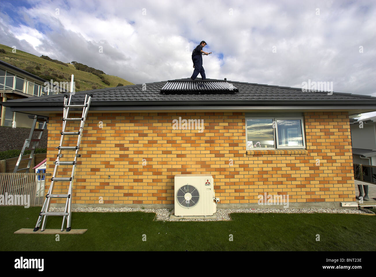 Qualified tradesman installing solar hot water system to a house ...