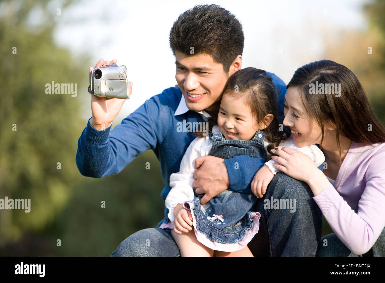 Young family making a home video at the park Stock Photo - Alamy