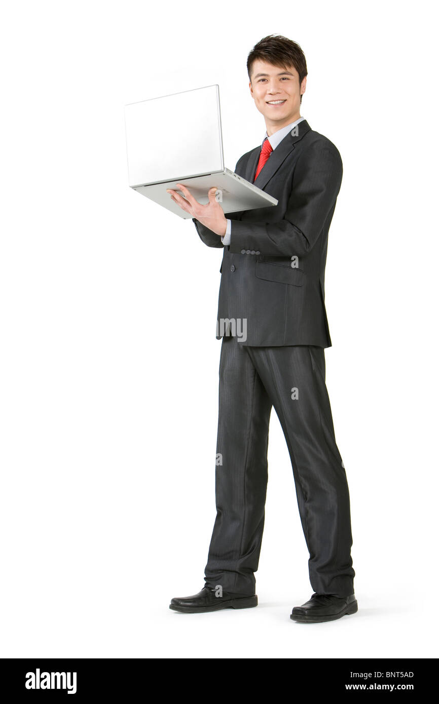 Young businessman holding a laptop Stock Photo - Alamy