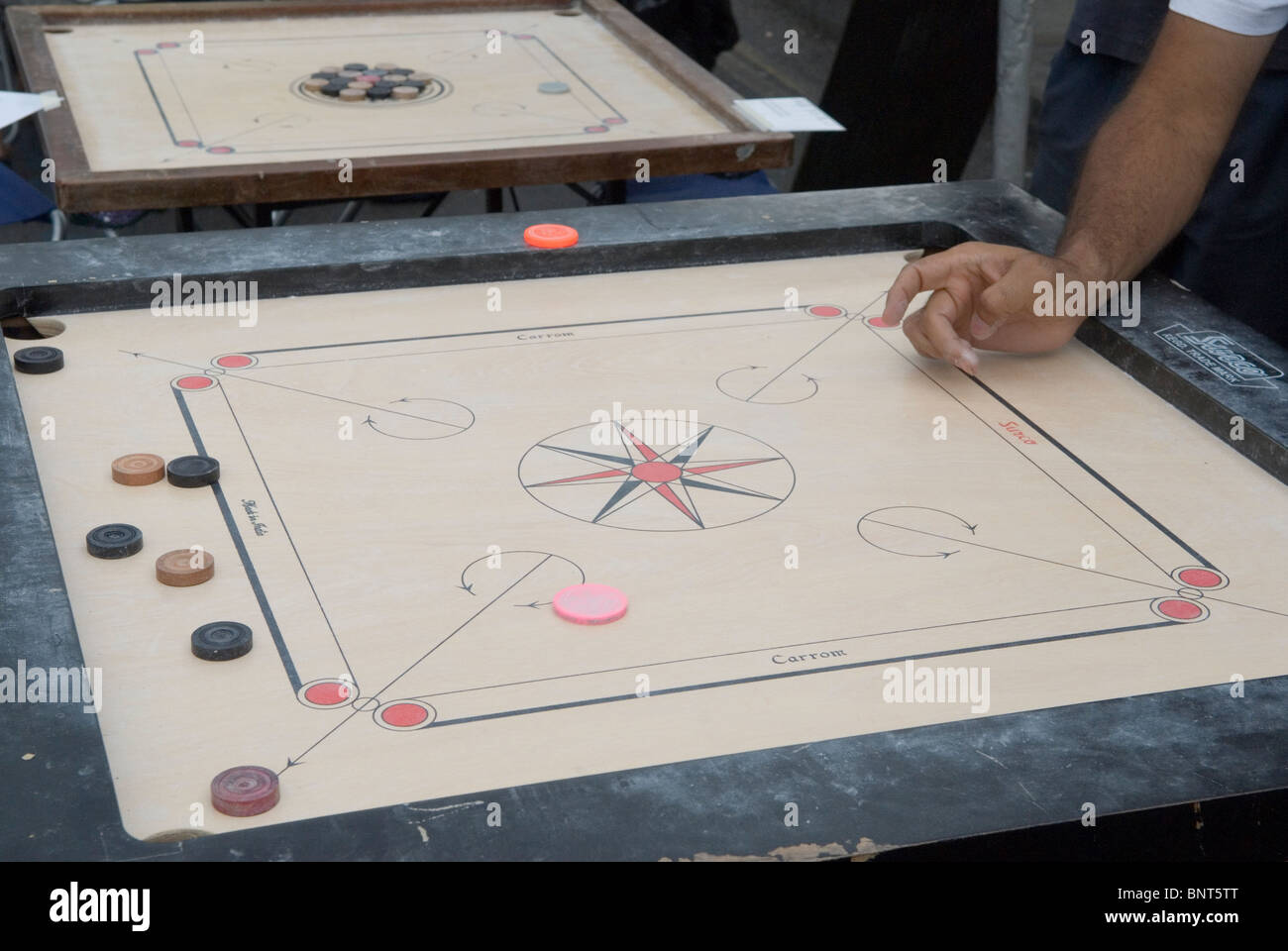 Carrom board game. Man playing the game. Carrom is a tabletop game of ...