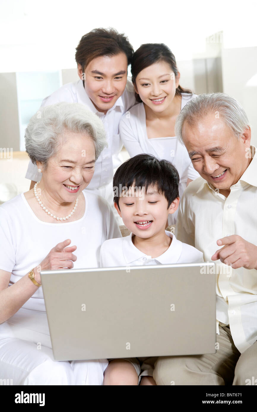 Multi generation family using a laptop Stock Photo - Alamy