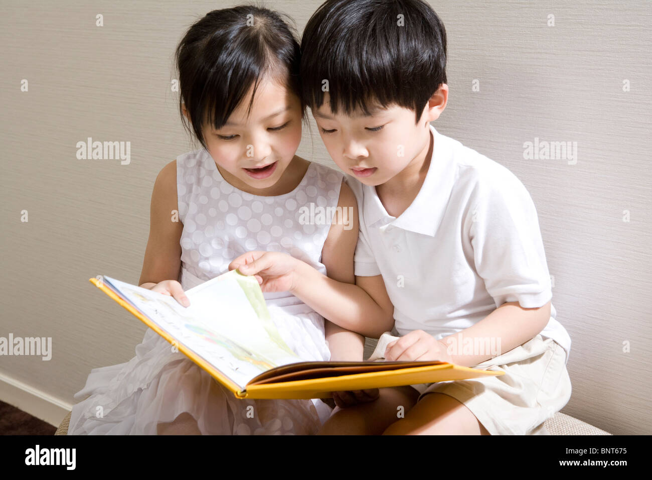 Brother and sister reading together Stock Photo - Alamy