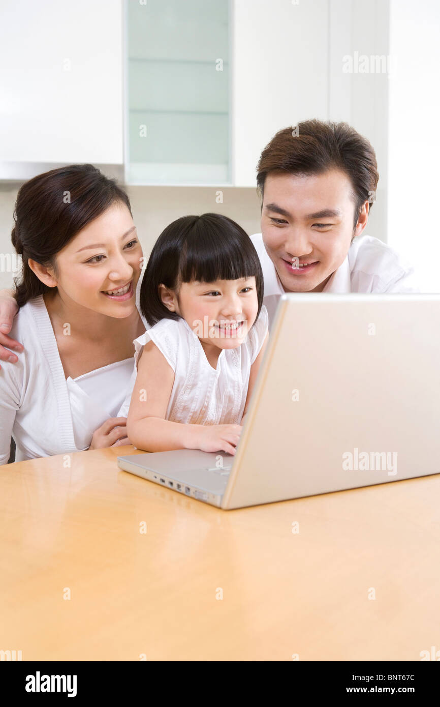 Little girl using laptop with her parents Stock Photo - Alamy