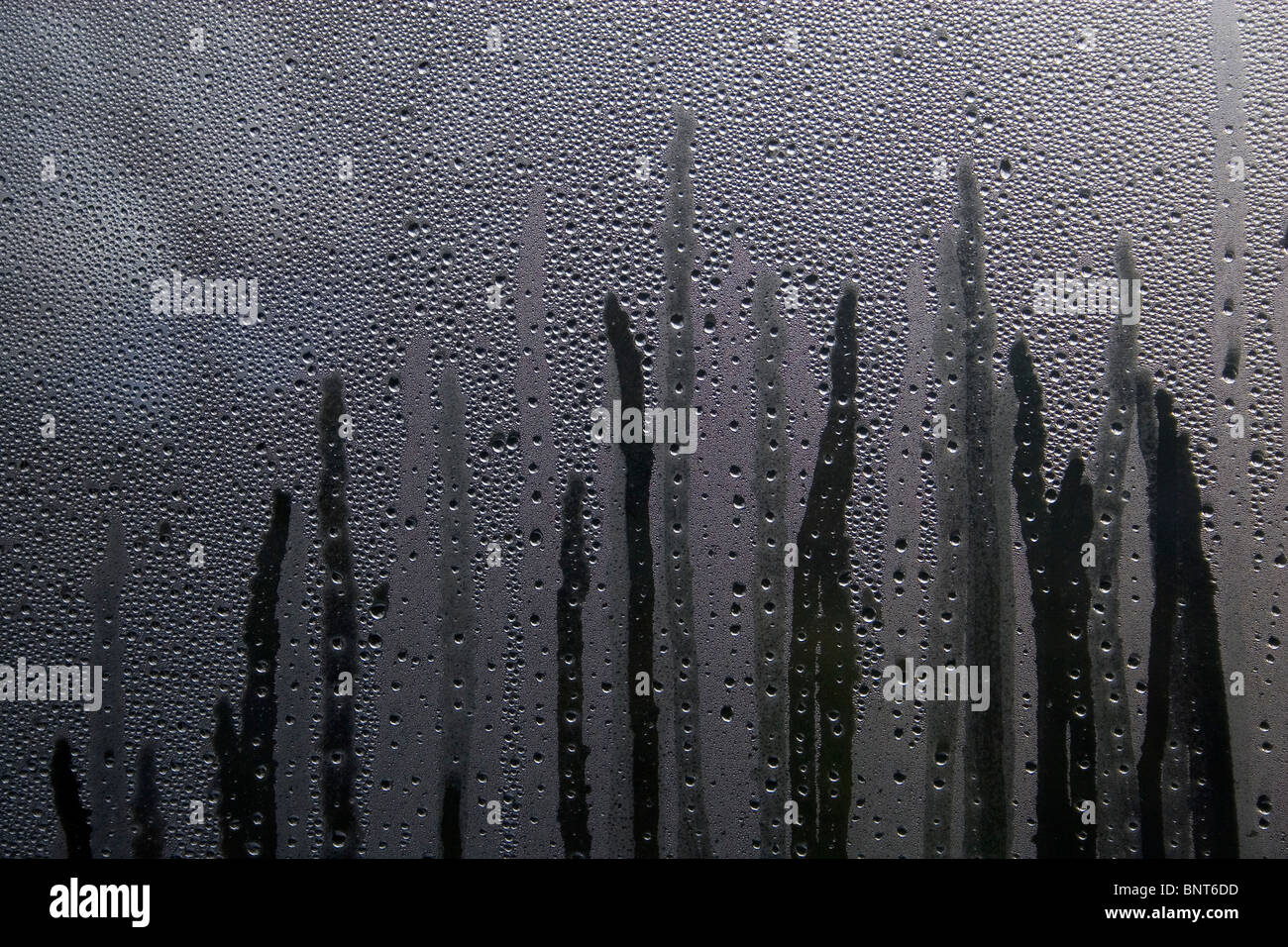 Water condensing and streaking down window Stock Photo - Alamy
