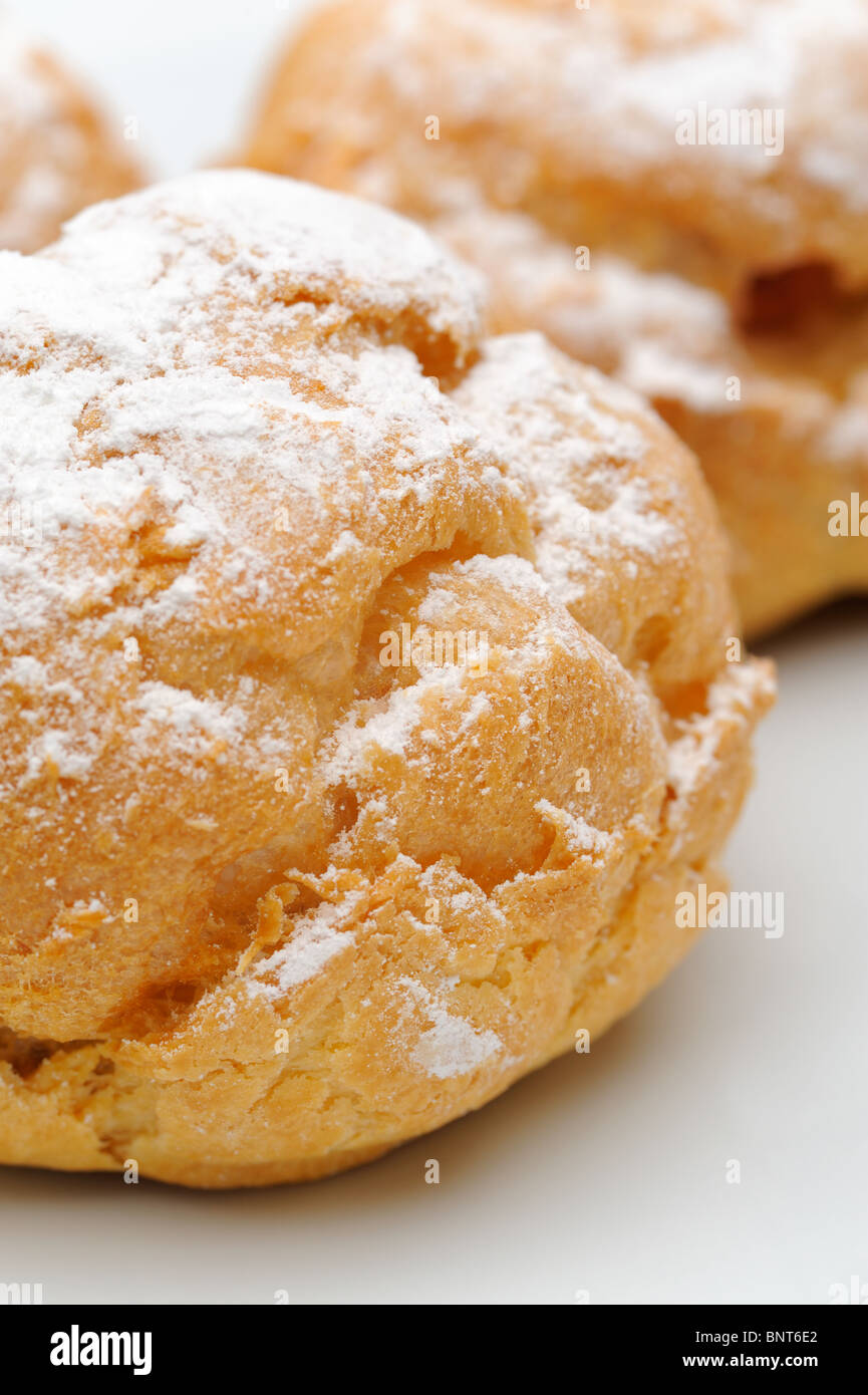 Three profiteroles on a plate, isolated, white background Stock Photo ...