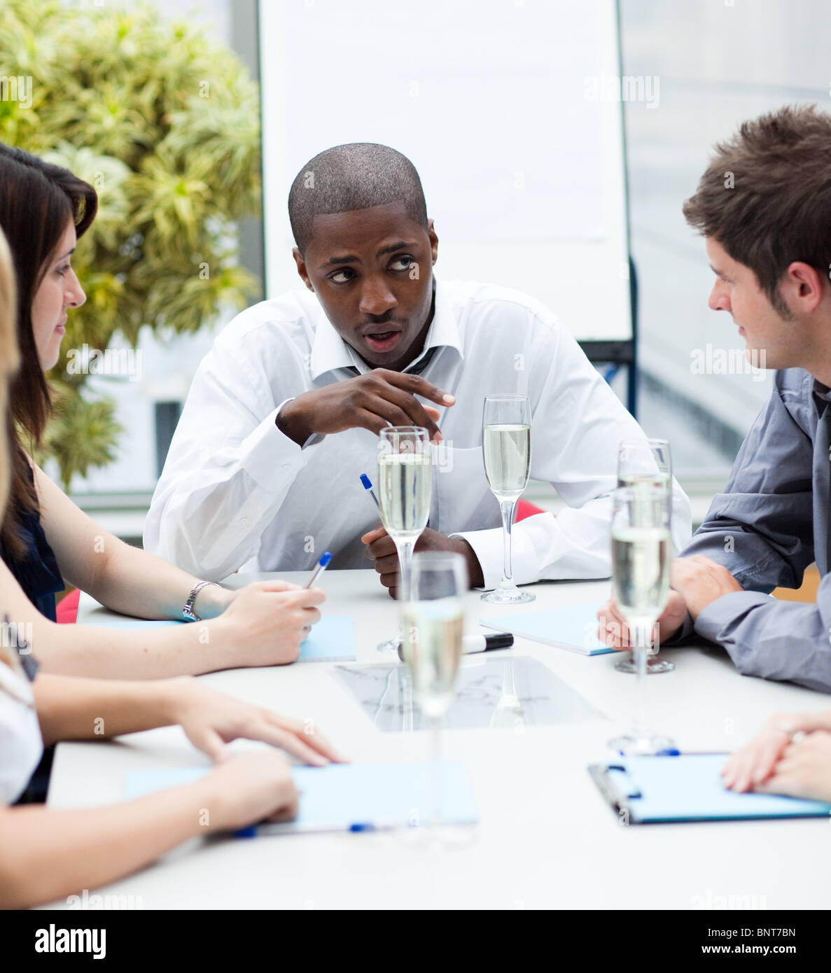 Ethnic manager speaking in a meeting with champagne Stock Photo - Alamy