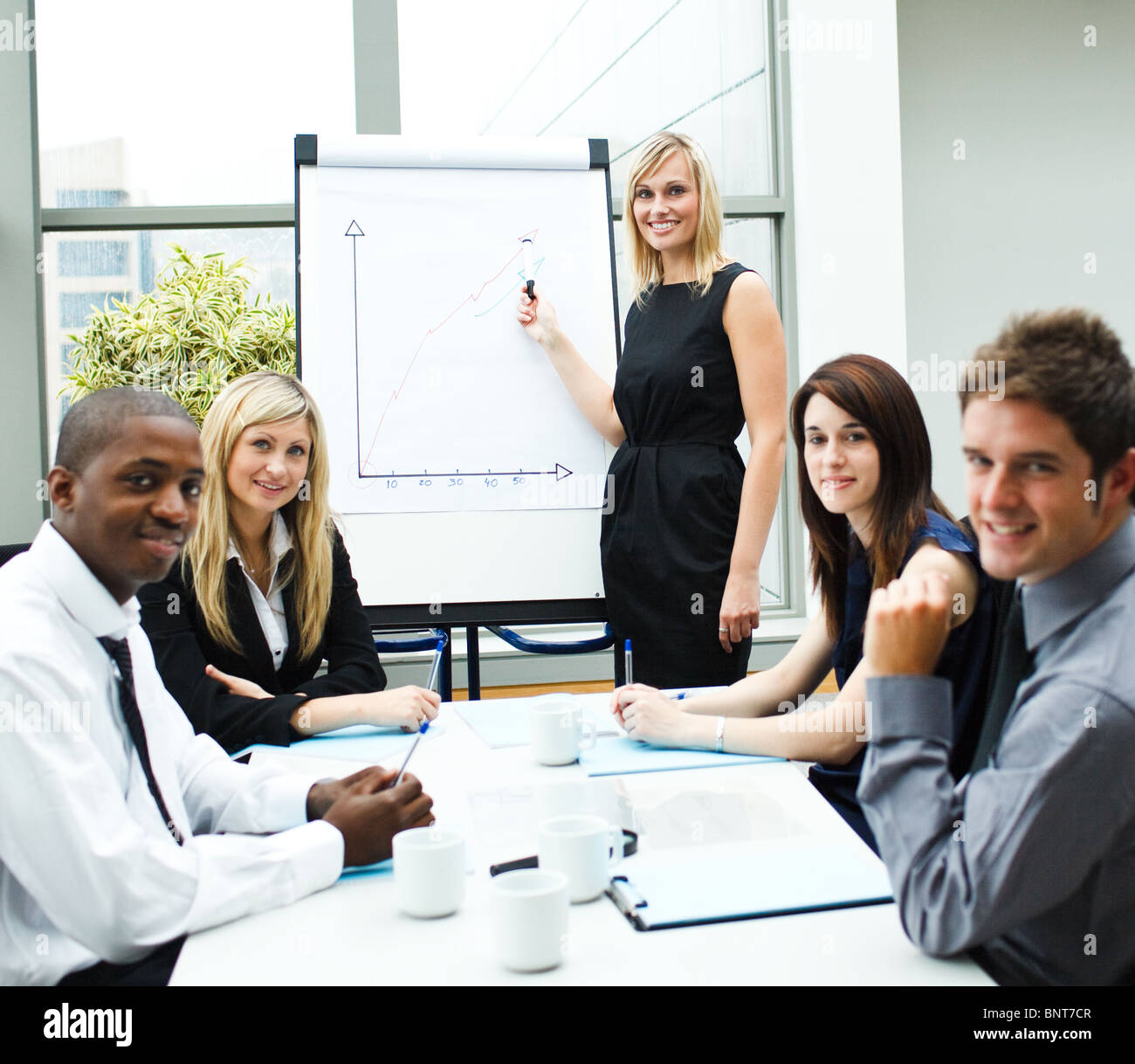 Attractive businesswoman giving a presentation smiling at the camera ...