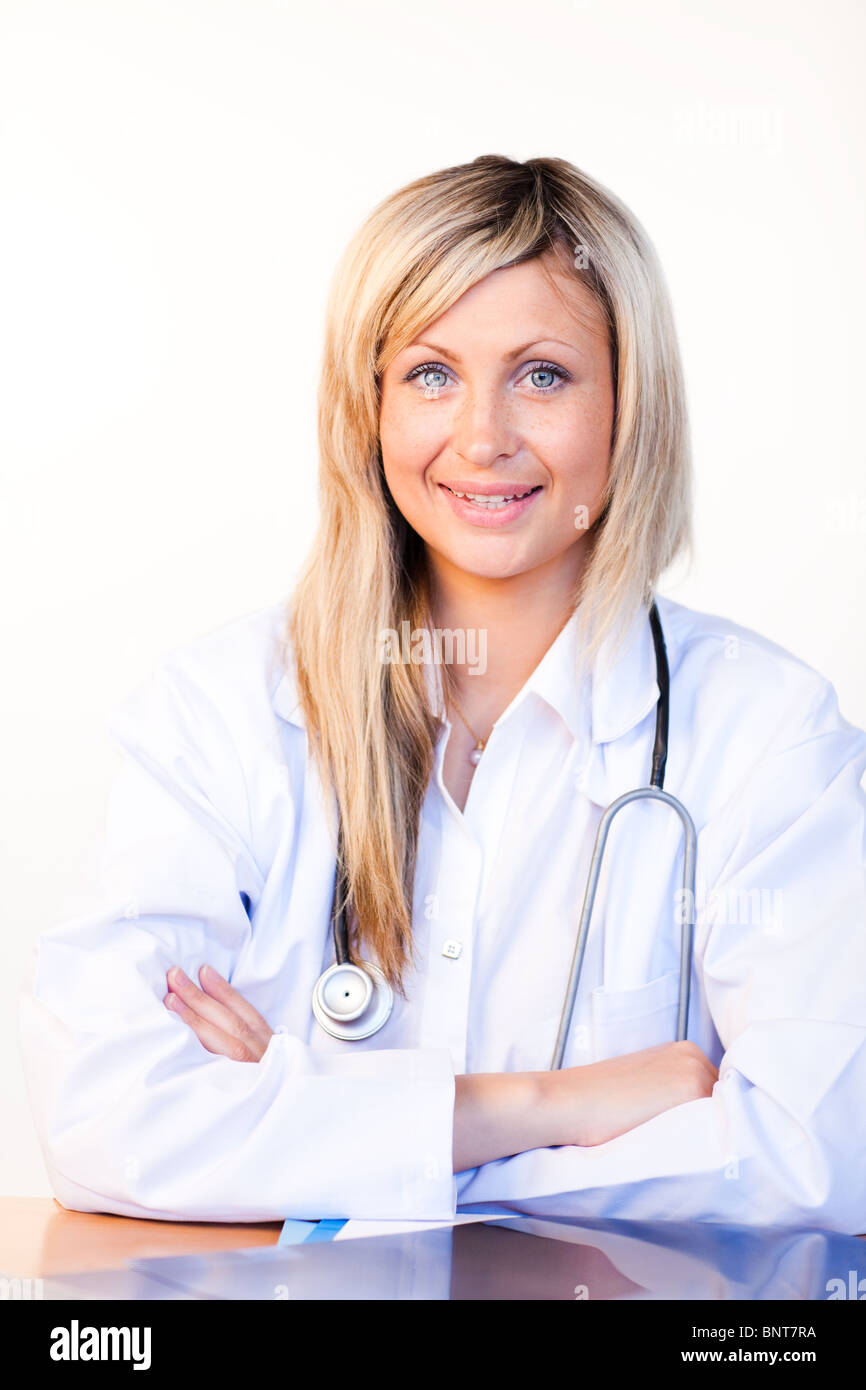 Blonde doctor sitting in an office and smiling at the camera Stock ...