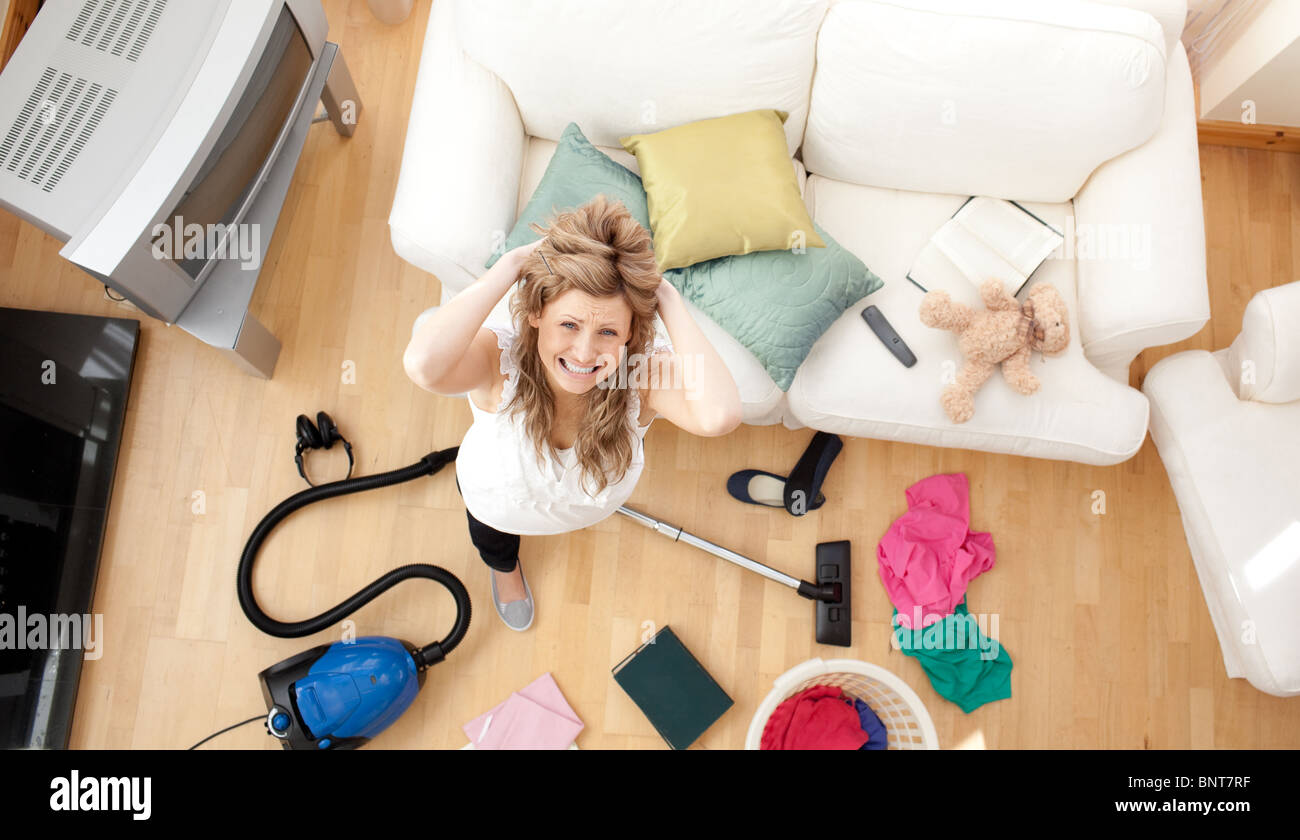 Frustrated blond woman vacuuming the living-room Stock Photo - Alamy