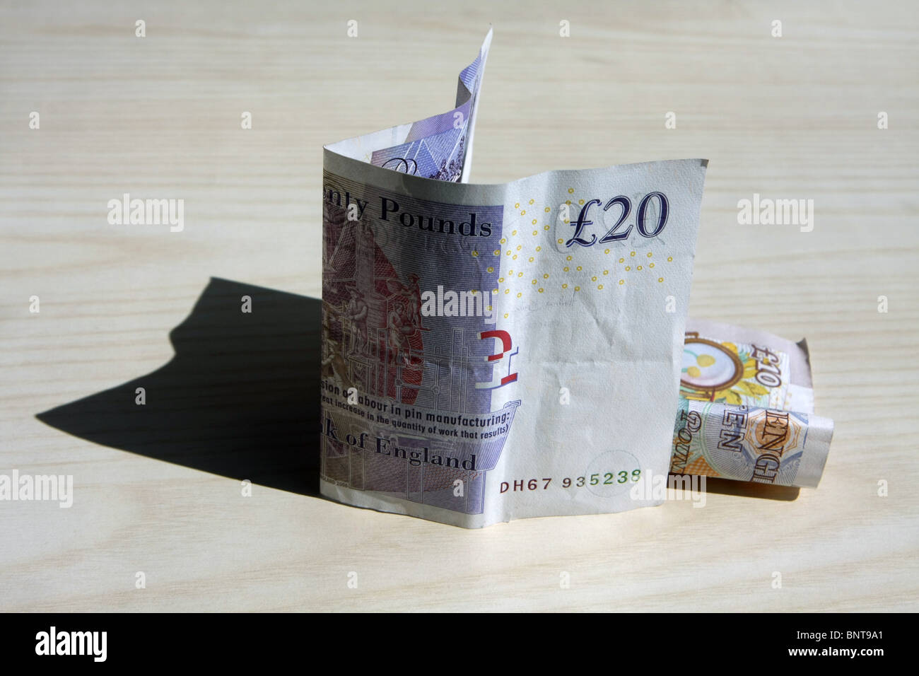 a part-folded sterling £20 note and £10 note Stock Photo - Alamy