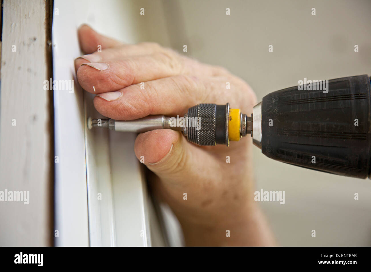 Prairieville, Michigan - A man uses a cordless drill to install a ...
