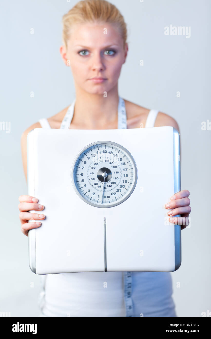 Fit young woman holding a scale hi-res stock photography and images - Alamy