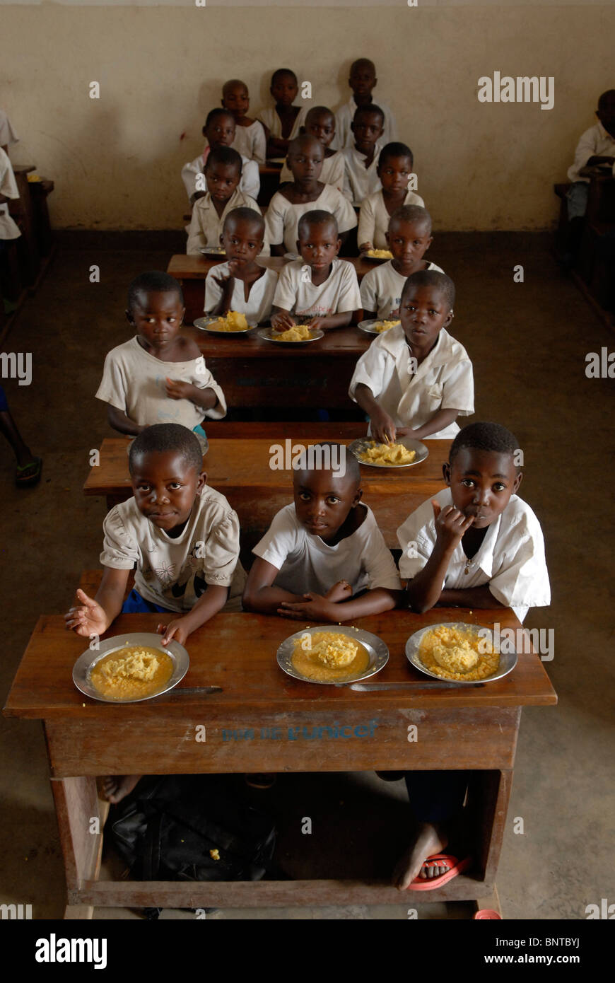 Schoolchildren eat with their hands at lunch time in a primary ...
