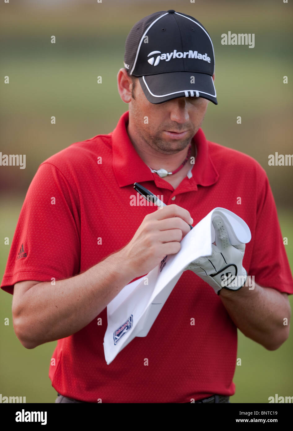 Defending champion Sergio Garcia signs an autograph on the practice tee ...