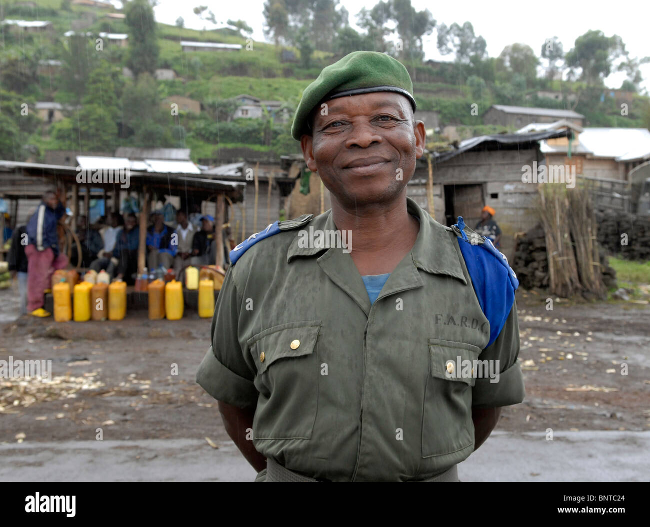 A FARDC Congolese government officer smiles at the camera as he stands ...