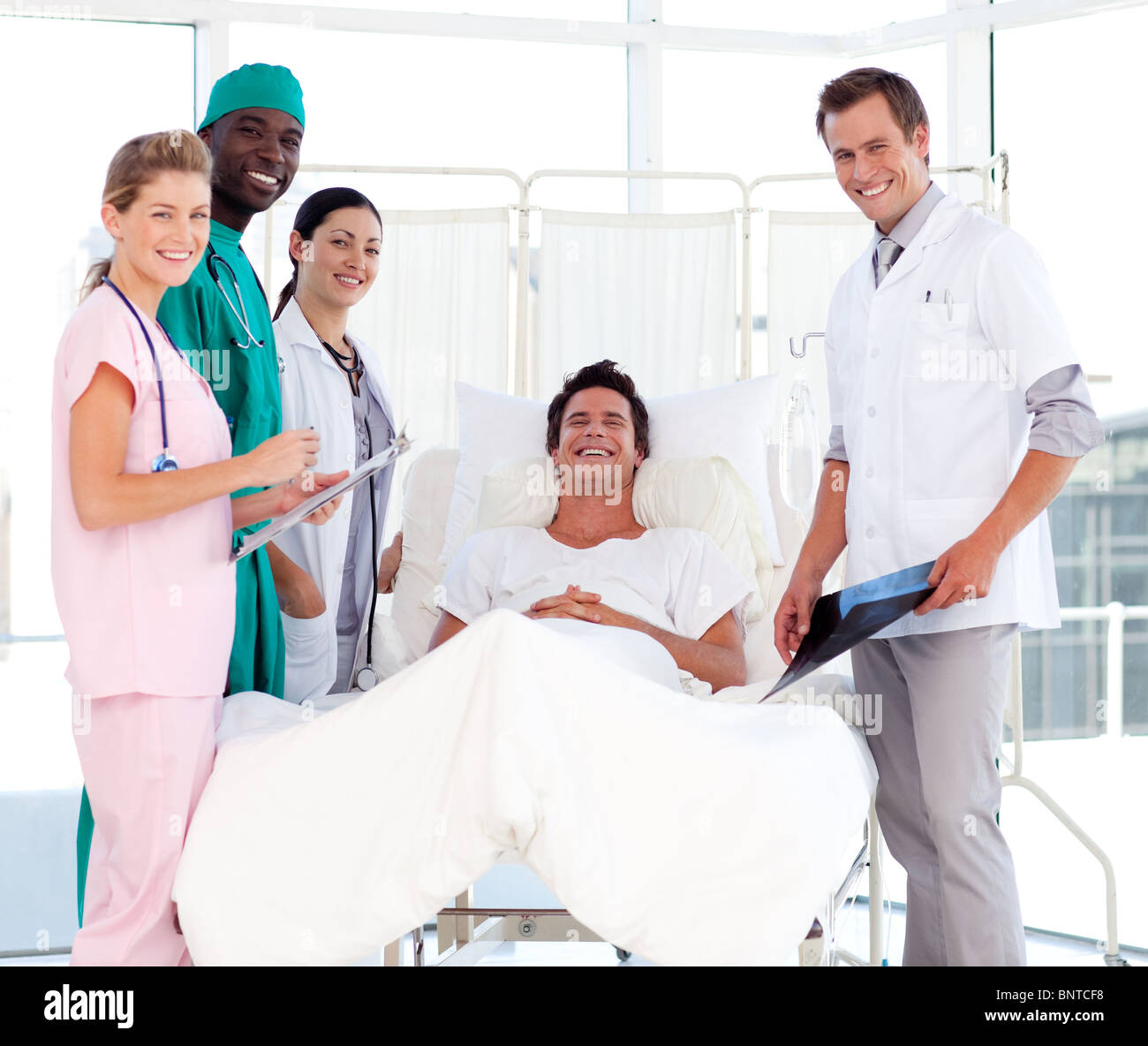 Doctors attending to a patient smiling at the camera Stock Photo - Alamy