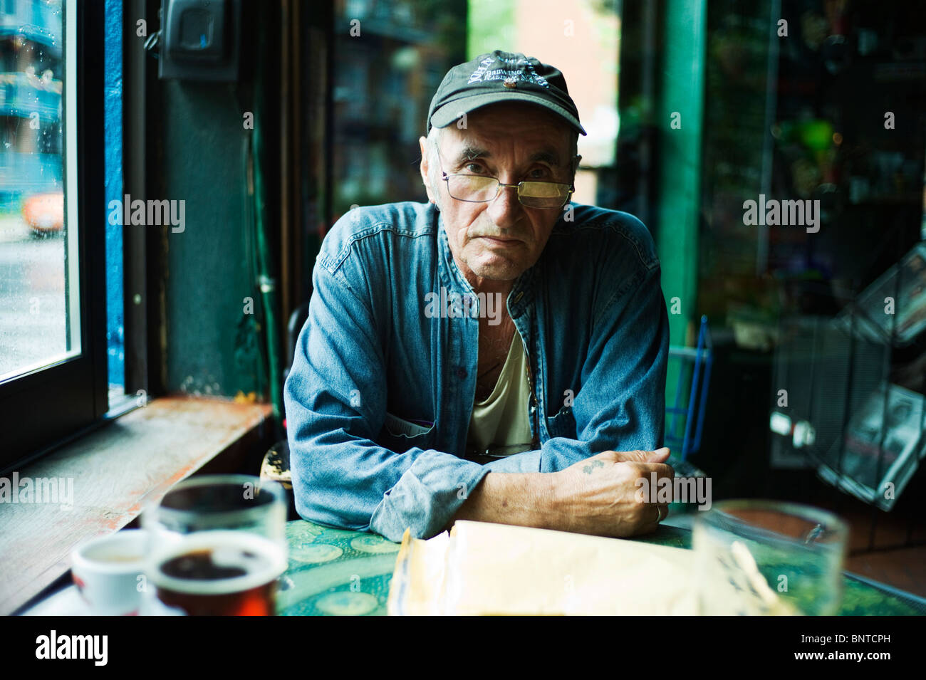 Old man at bar table looks at camera Stock Photo - Alamy