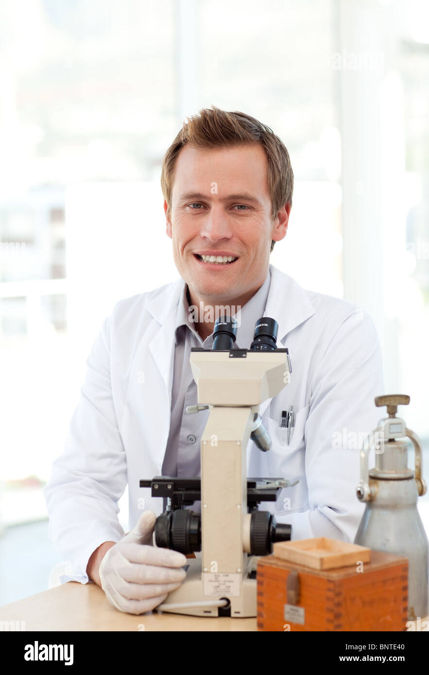 Male scientist looking through a microscope Stock Photo - Alamy