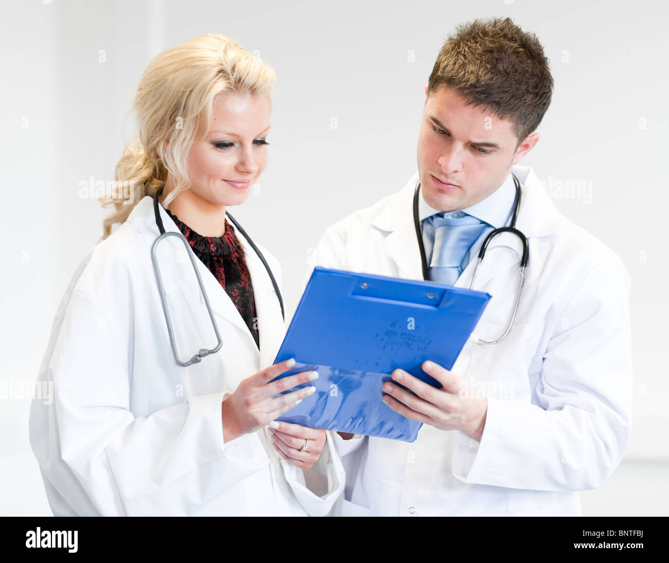 Team of doctors looking at a report Stock Photo - Alamy