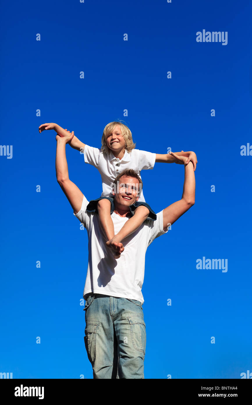 Boy sitting on his father's shoulders Stock Photo - Alamy