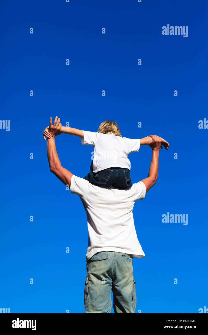 Son sitting on his father's shoulders Stock Photo - Alamy