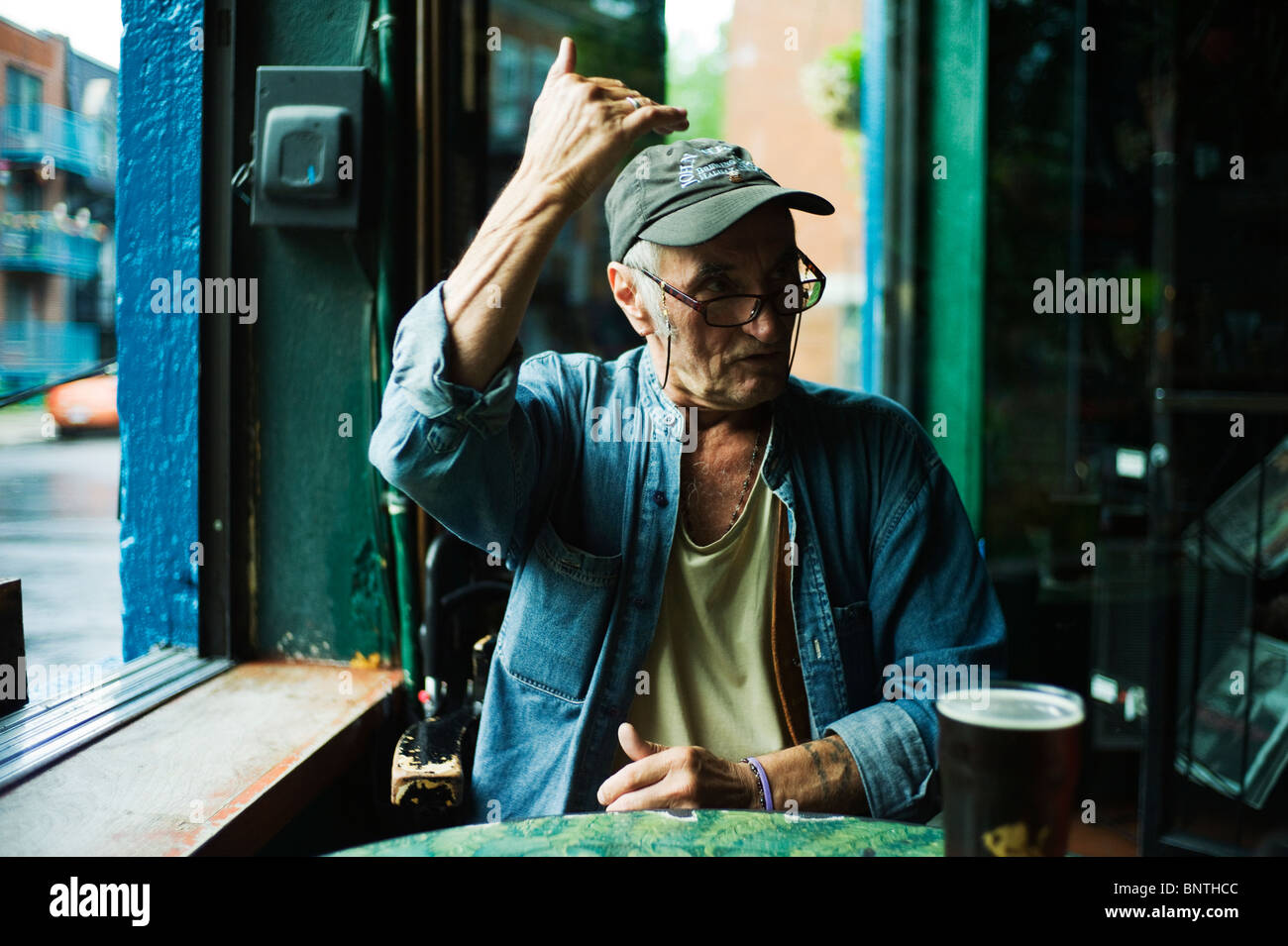 Old man gestures at bar table Stock Photo - Alamy