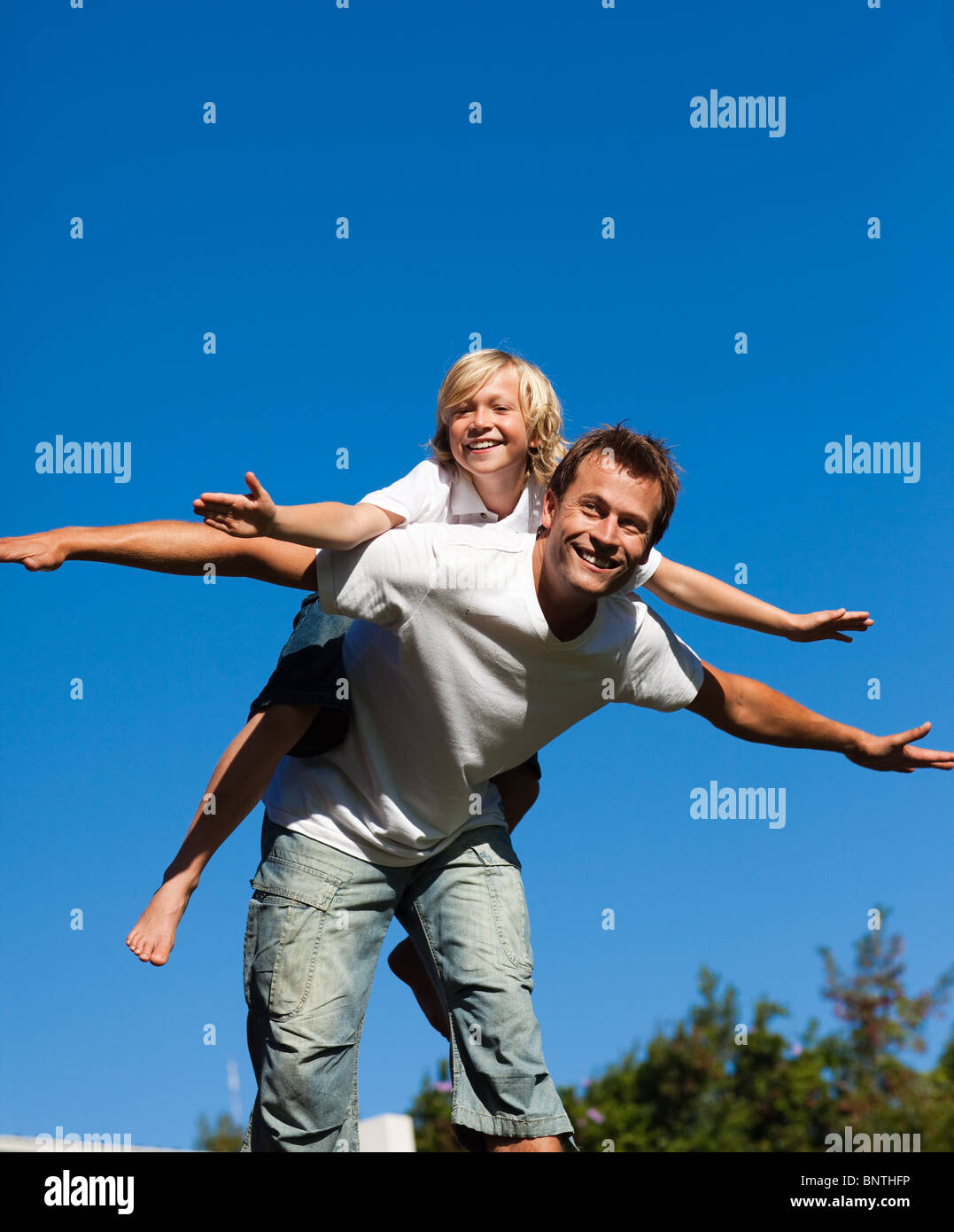 Happy man giving young boy piggyback ride Stock Photo - Alamy