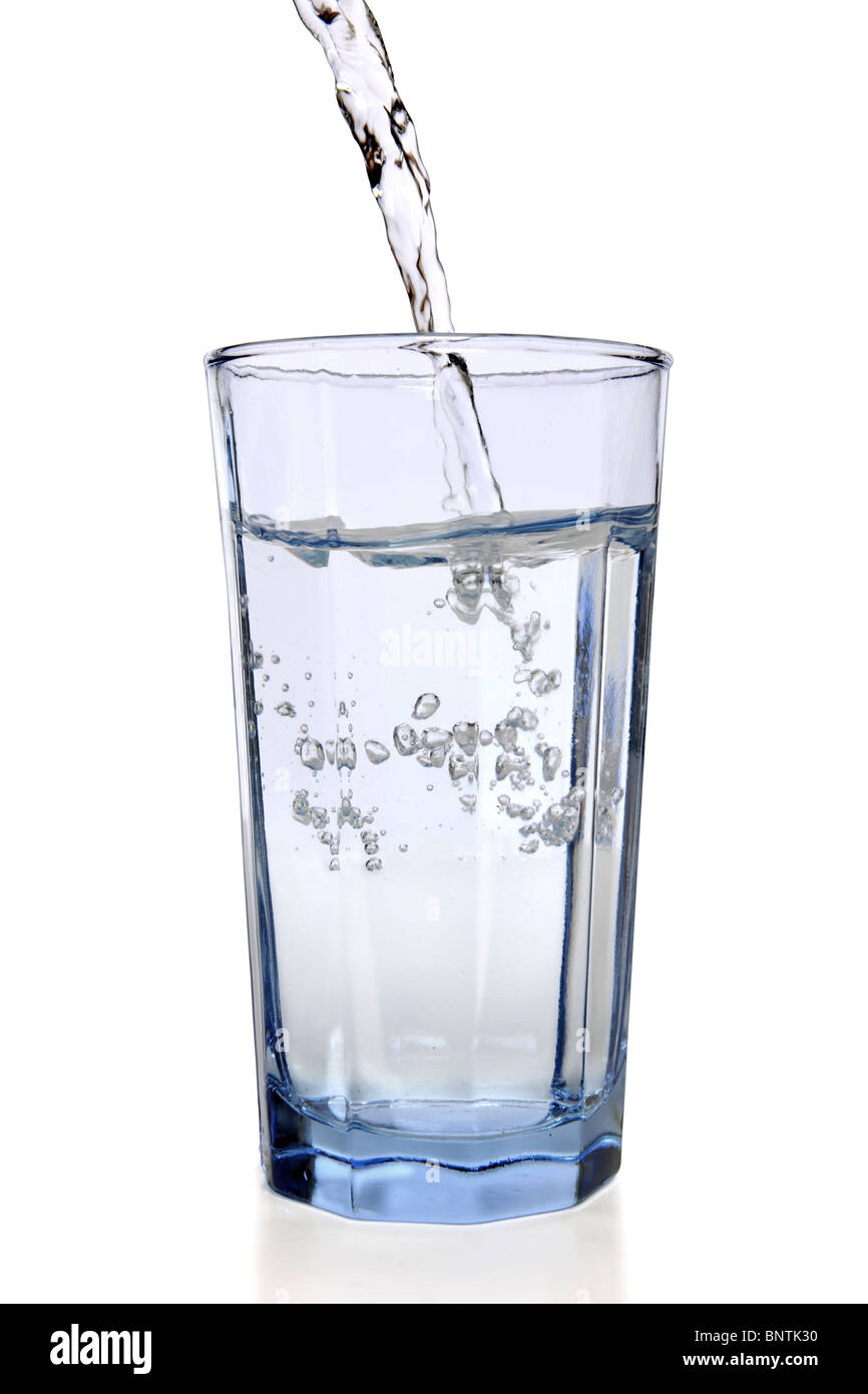 Water filling glass isolated over white background - With clipping path ...