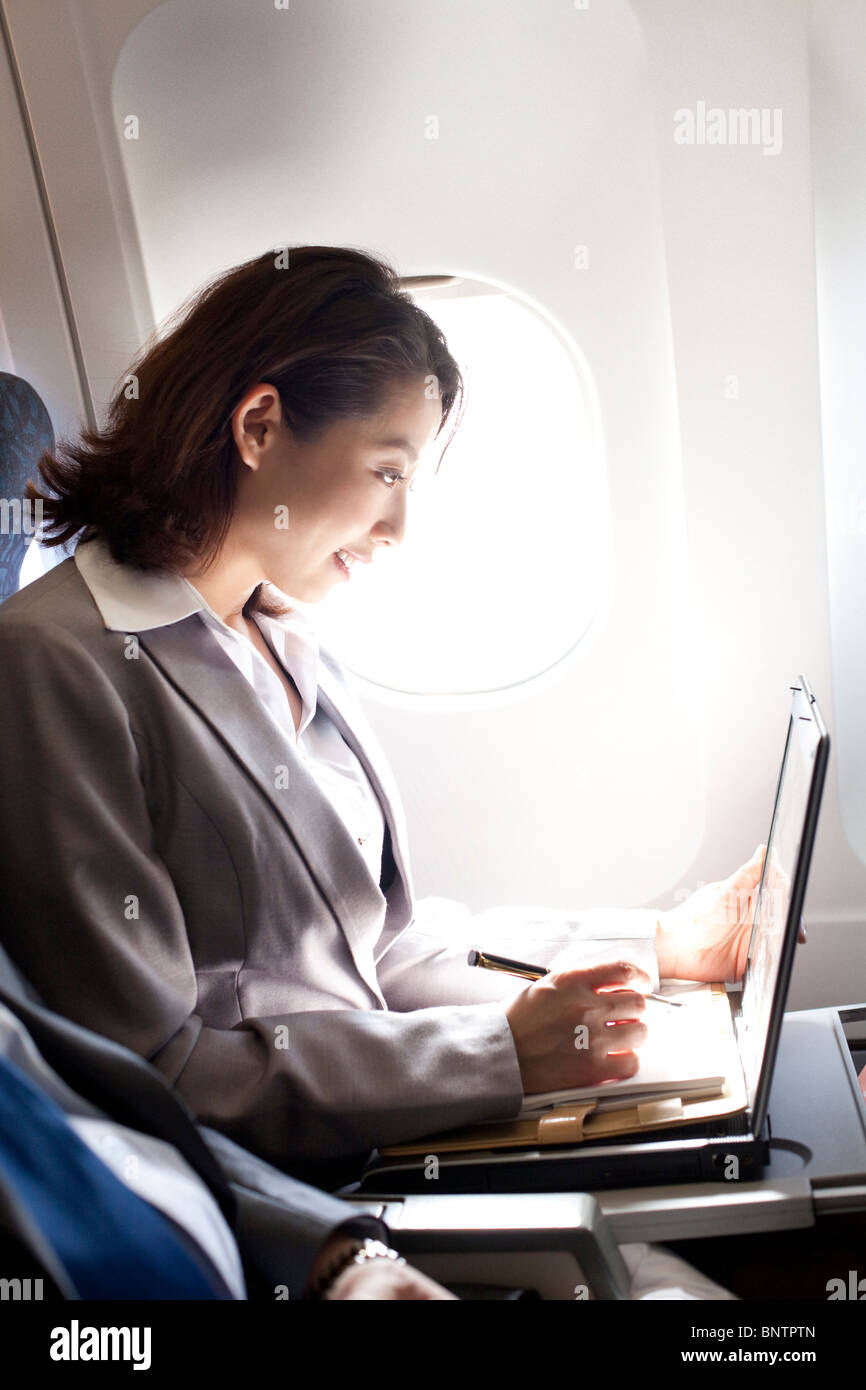 Businesswoman working on laptop plane hi-res stock photography and ...