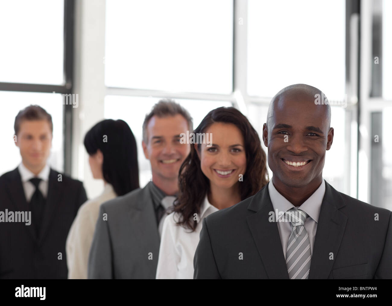 Five person Business team looking at camera and smiling Stock Photo - Alamy