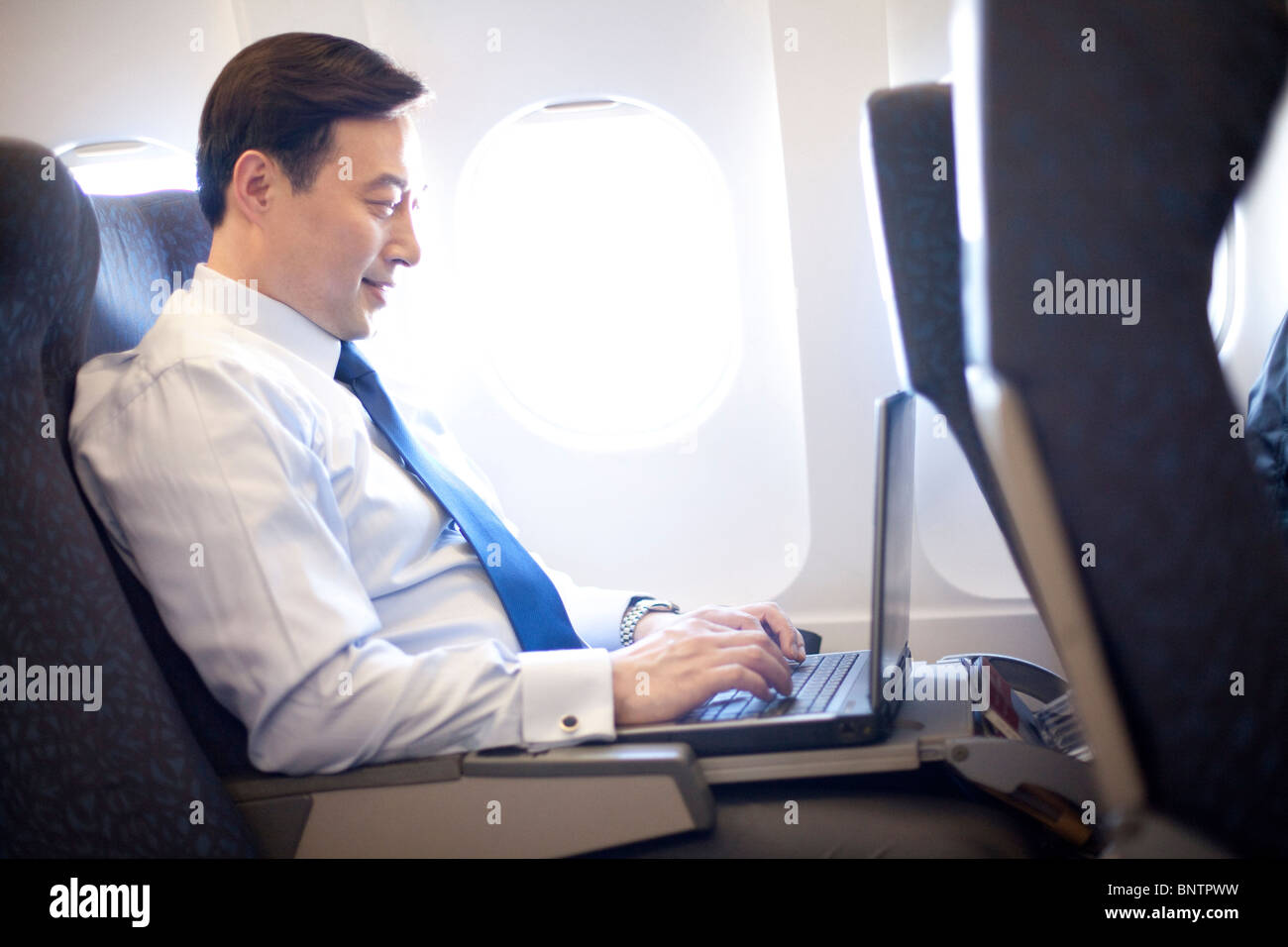 Businessman working on the plane Stock Photo - Alamy
