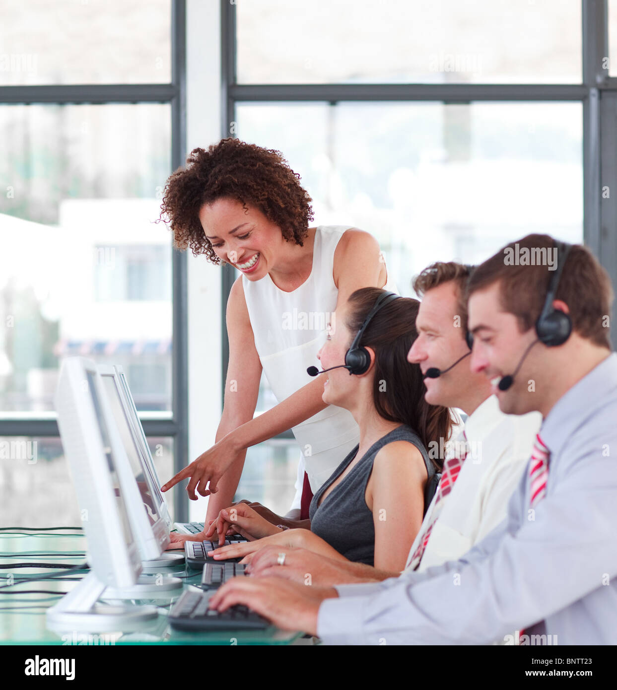 Charming manager checking his young team work Stock Photo - Alamy