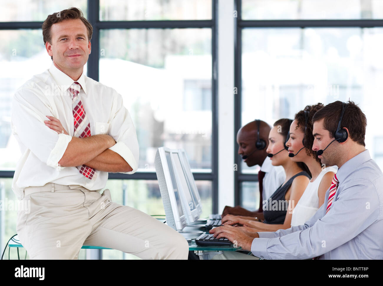 Senior manager with crossed arms in a call center Stock Photo - Alamy