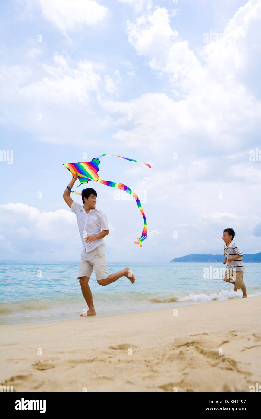 Father And Son Flying A Kite A Beach Family High Resolution Stock ...