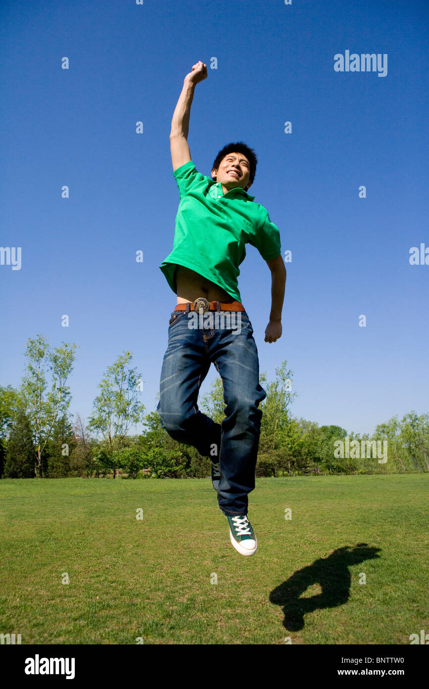 Young man jumping in air at park Stock Photo - Alamy