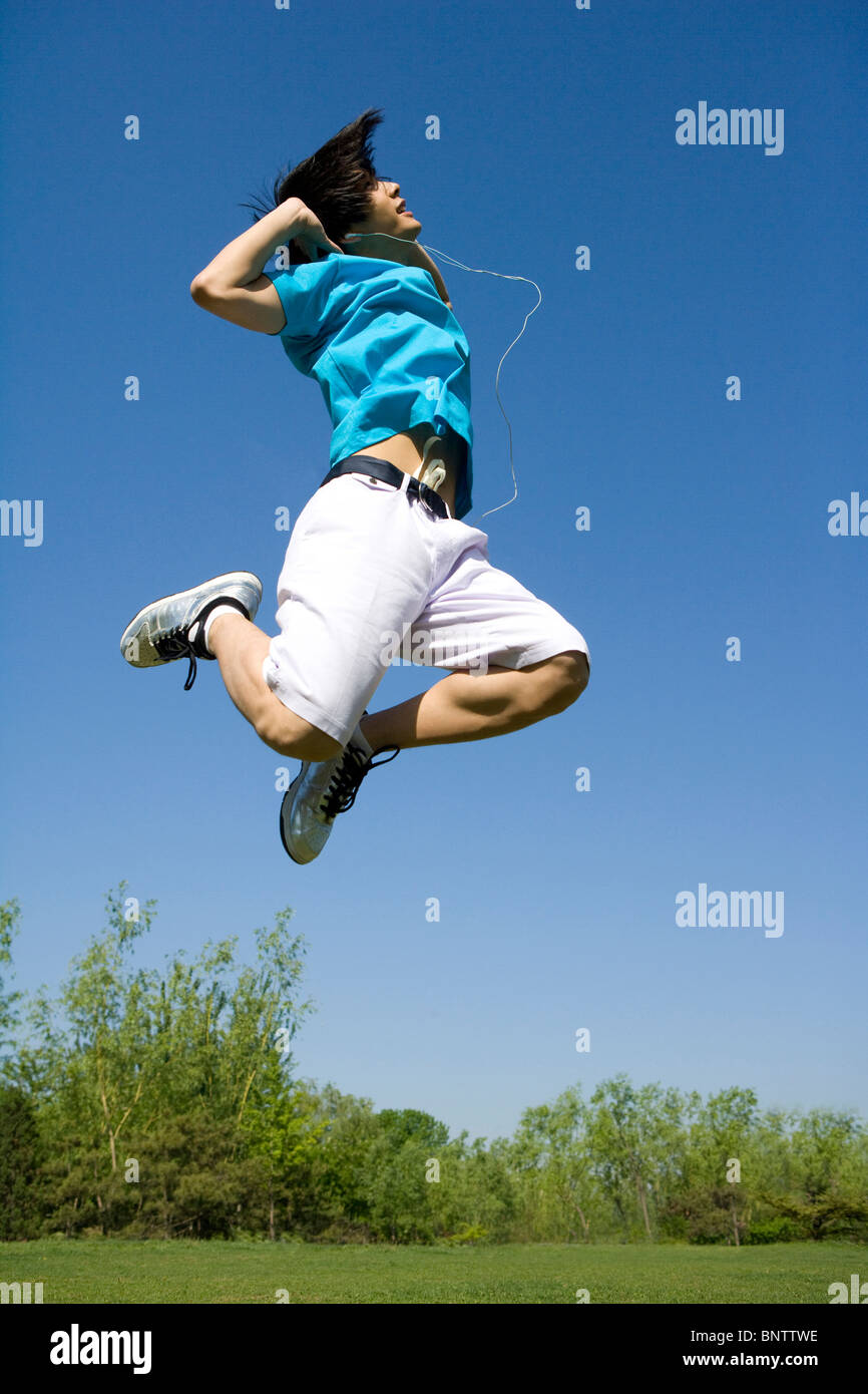 Young man jumping in air at park Stock Photo - Alamy