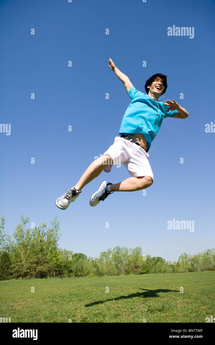 Young man jumping in air at park Stock Photo - Alamy