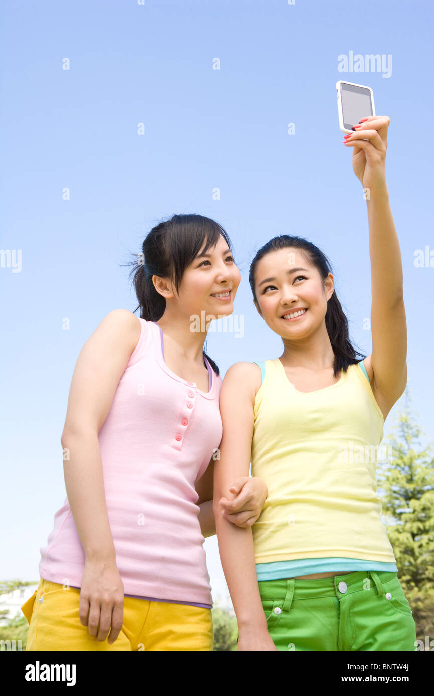 Two young women with a mobile phone Stock Photo - Alamy