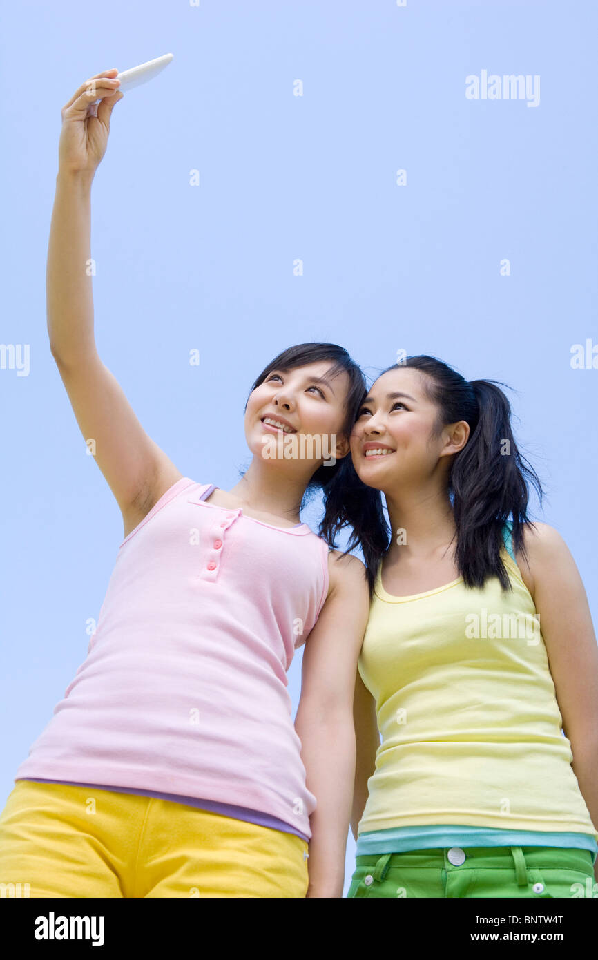Two young women with a mobile phone Stock Photo - Alamy