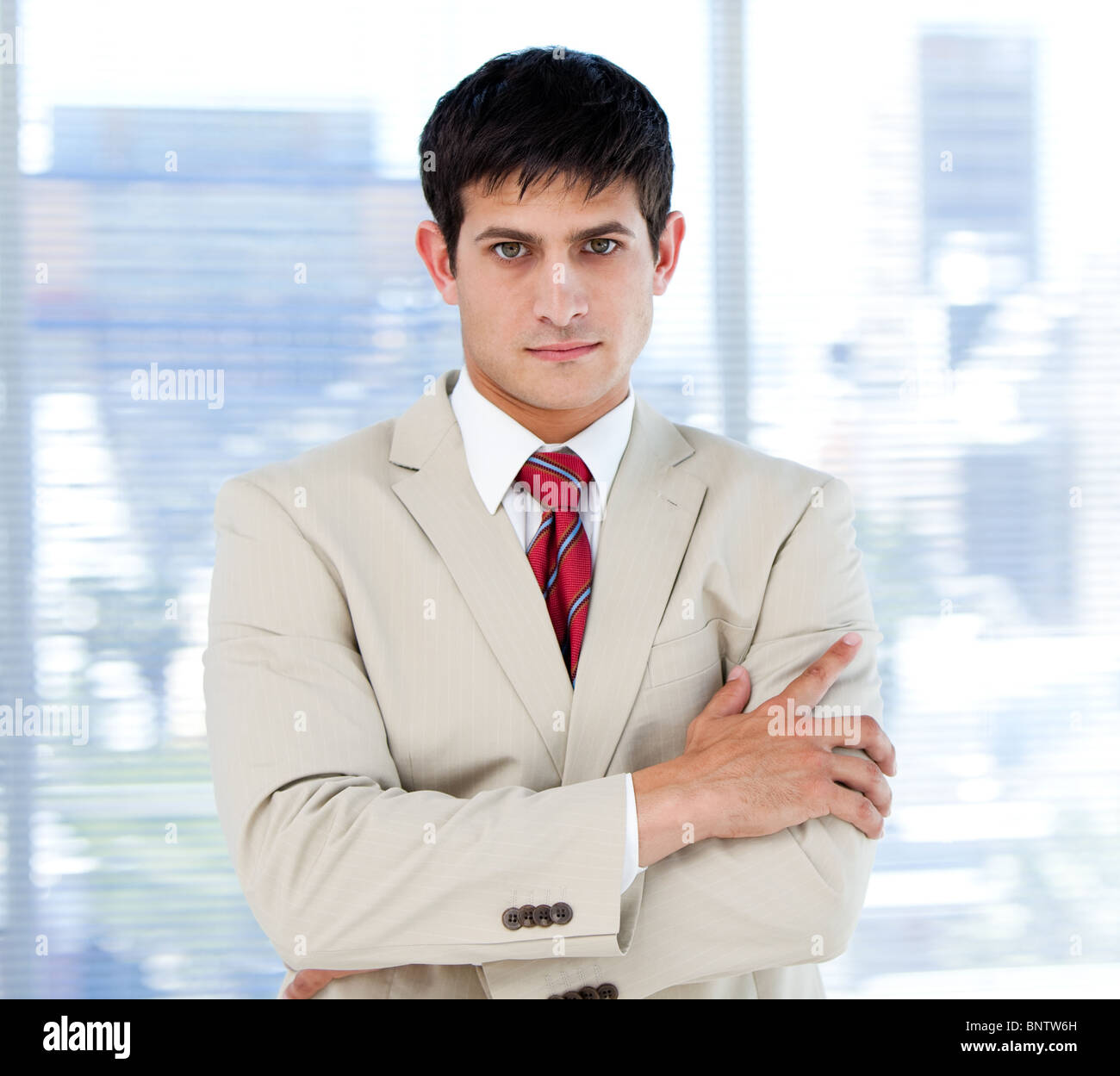 Self-assured businessman with folded arms standing Stock Photo - Alamy