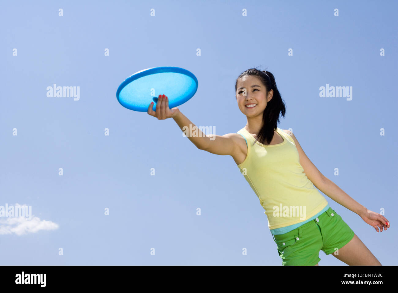 Young woman throwing a Frisbee Stock Photo - Alamy