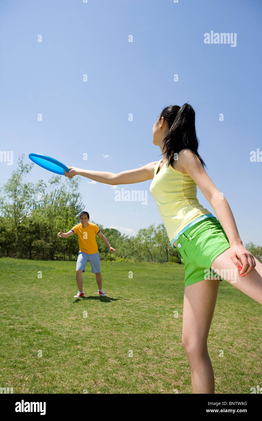 Young woman throwing a Frisbee Stock Photo - Alamy