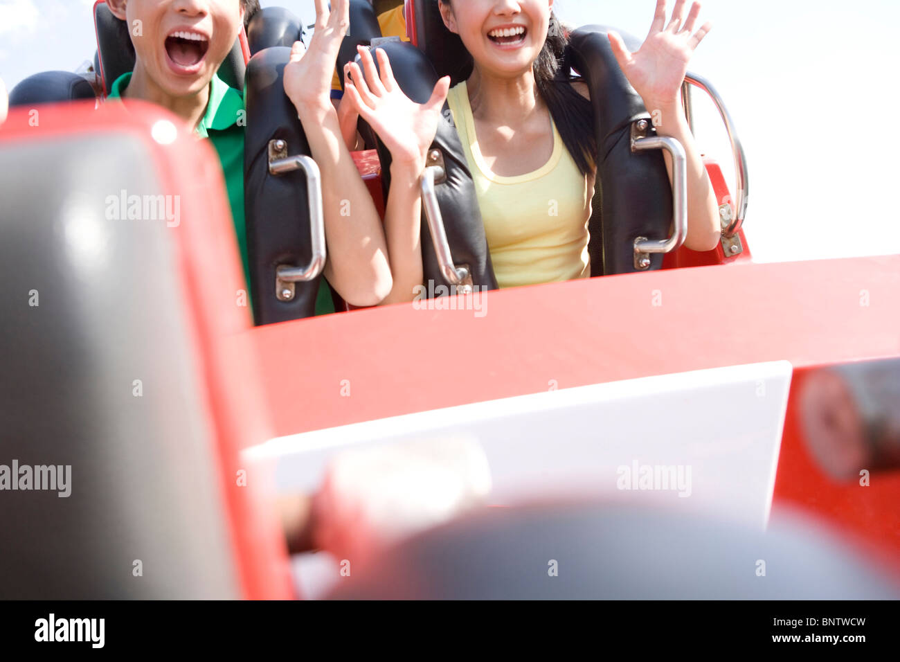 Young people riding a rollercoaster Stock Photo - Alamy